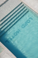 Piscina com superfície de água cristalina e escada.