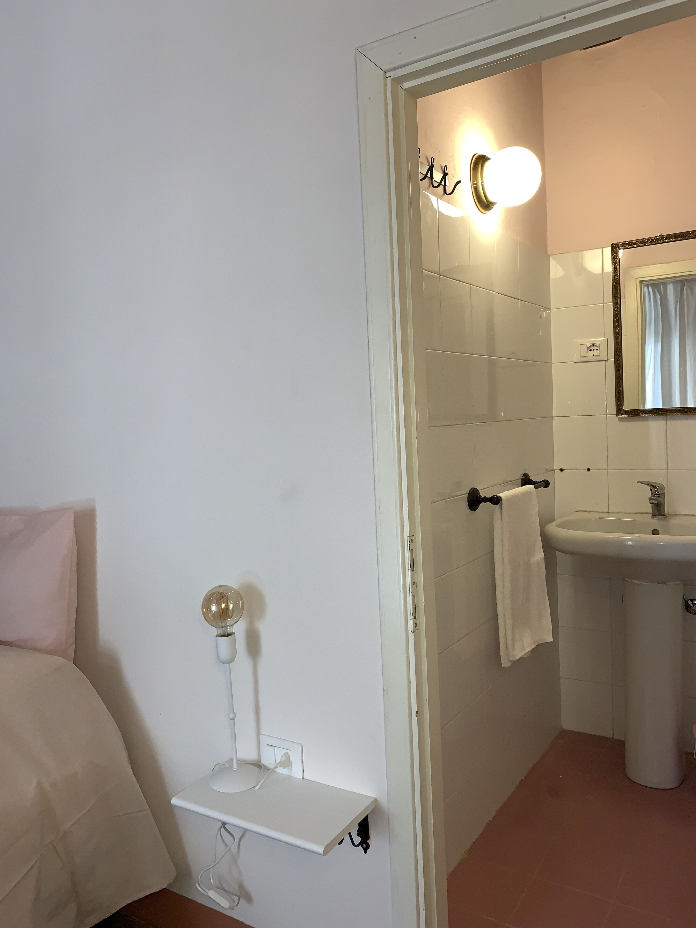 Uma casa de banho com lavatório, espelho e porta-toalhas.