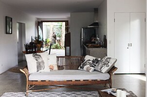 Uma sala de estar moderna com sofá, área de jantar e cozinha.