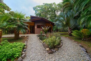 Uma casa moderna rodeada por vegetação tropical exuberante.