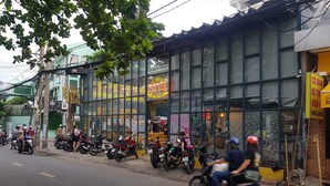Cena de rua com uma fileira de motocicletas estacionadas e um prédio com grandes janelas e uma placa que diz "FOXTEL".