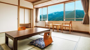 Um quarto japonês tradicional com tatames, uma mesa baixa e cadeiras de madeira.