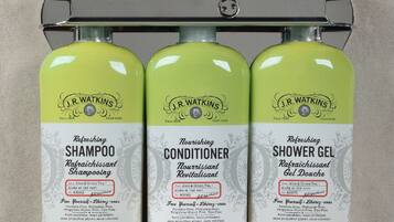 Três embalagens de produtos J.R. Watkins: shampoo, condicionador e gel de banho, cada uma com etiqueta verde e base branca.
