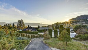 Uma área residencial com casas, uma entrada de automóveis e uma montanha ao fundo.