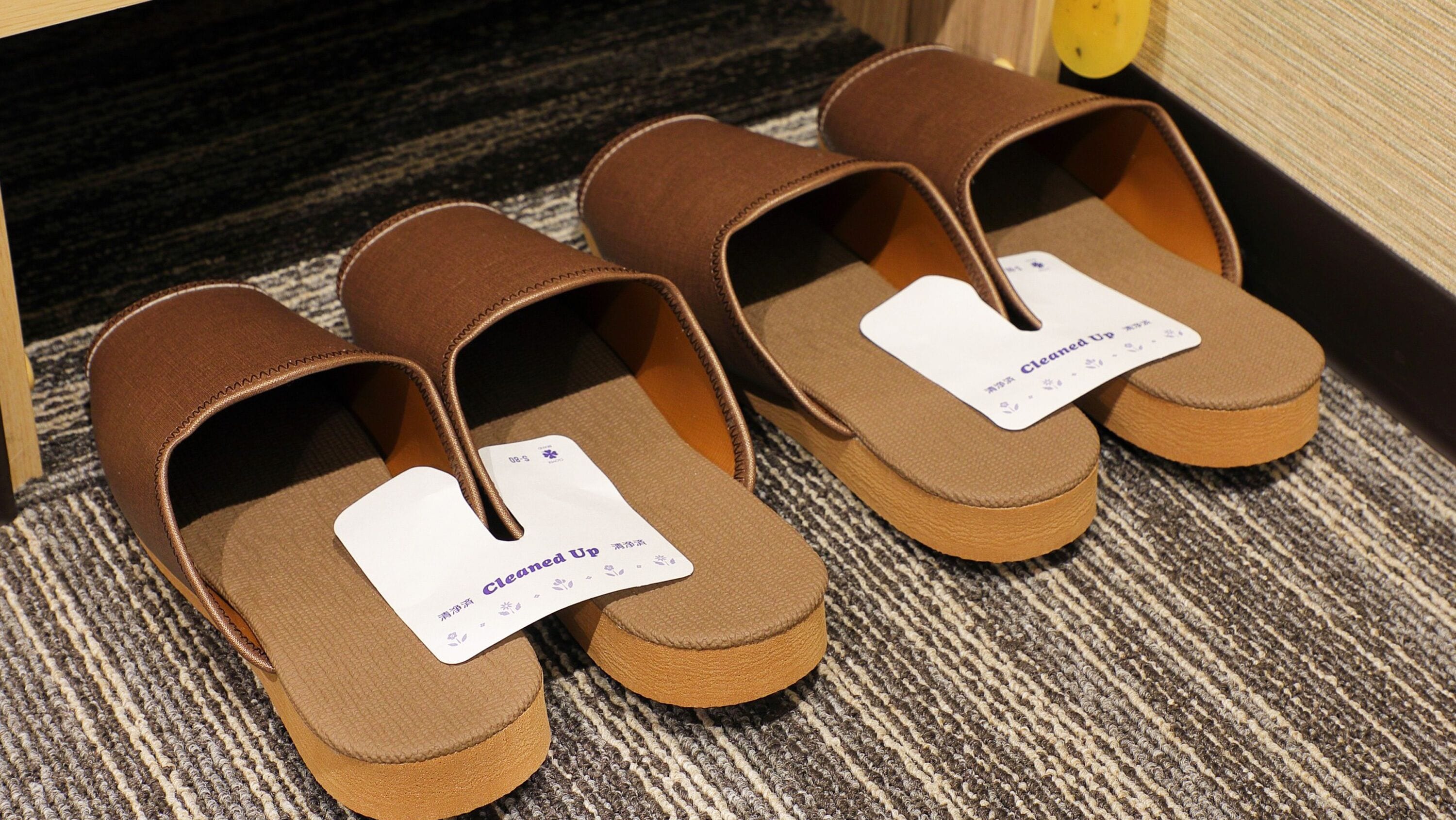 Um par de sapatos marrons com etiquetas que dizem 'Limpo'.