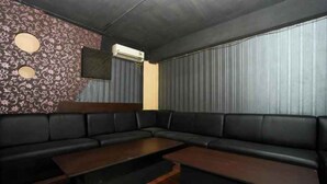 Um interior moderno com um sofá de canto, uma mesa de centro de madeira e papel de parede estampado.