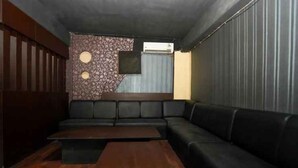 Uma sala de estar moderna com um sofá modular, uma mesa de centro de madeira e uma parede estampada.