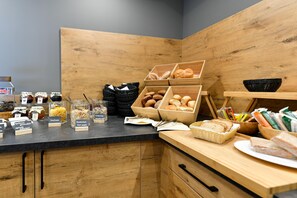 Um buffet de café da manhã com diversos alimentos e acompanhamentos.