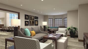 Quarto de hotel com sofá, poltronas, mesa de jantar e uma janela grande com persianas.