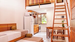 Quarto compacto e moderno com beliche, pequena cozinha e escada de madeira.