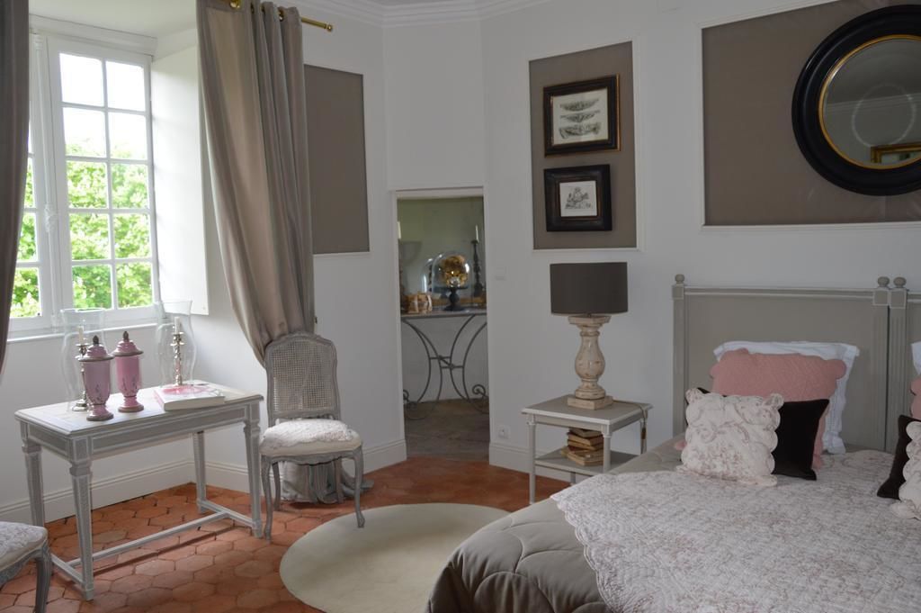 Um quarto com uma cama, uma cadeira, uma mesa e uma janela.