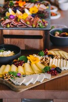 Tábua de frios com diversos queijos, frutas e nozes.