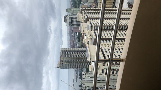 Um edifício alto com vista para outros edifícios e um céu nublado.