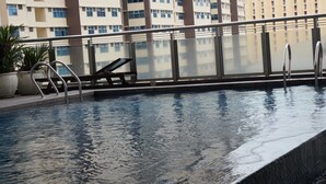 Uma piscina com grades de metal e um banco.