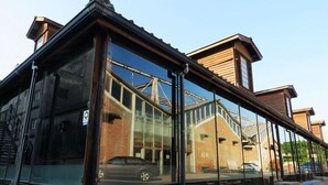 Um edifício moderno com grandes janelas de vidro e estrutura de metal.