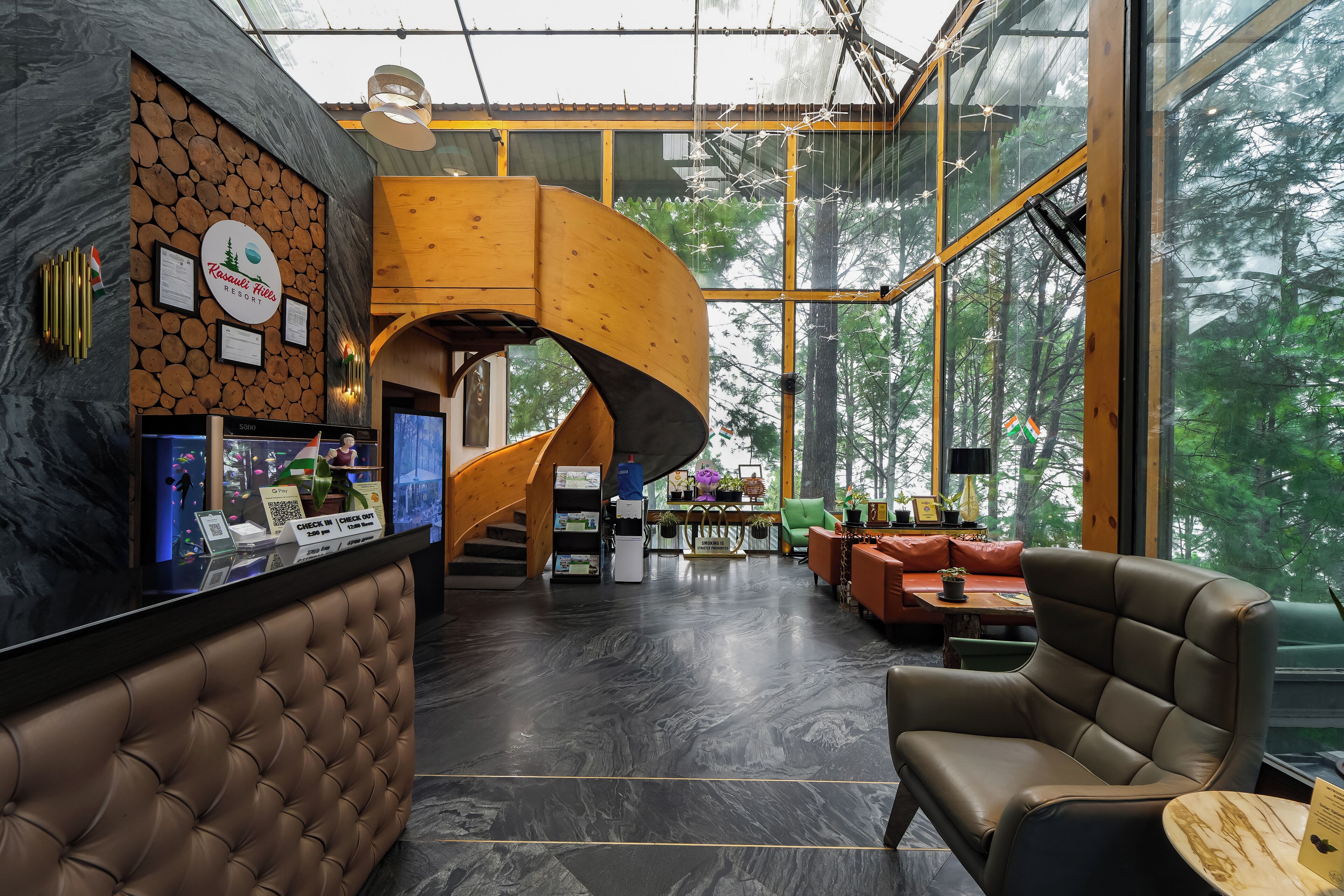 Uma área de recepção moderna com balcão de check-in, escada em espiral e sala de estar com sofás de couro.