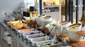 Disposição de buffet com diversos alimentos e utensílios.