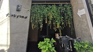 Entrada de um edifício com uma placa indicando "Parking" e outra com a frase "O céu em Chiang Mai".