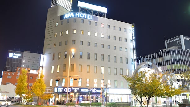 Um edifício de vários andares com uma placa bem visível do Hotel APA.