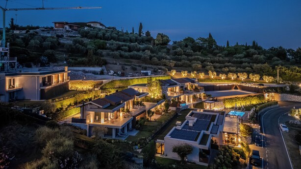 Uma área residencial com casas modernas, piscina e uma estrada sinuosa.