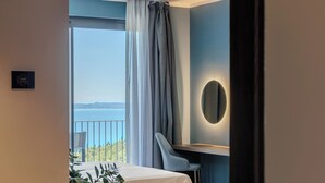 Quarto de hotel moderno com varanda, escrivaninha e cama.