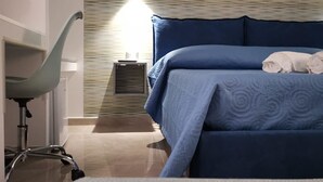 Um quarto com uma cama, uma escrivaninha e uma cadeira.