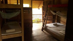 Uma cabana de madeira com beliches, uma escada e uma varanda.