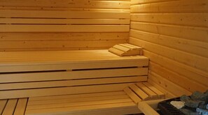 Uma sauna de madeira com bancos e um sistema de aquecimento em pedra.