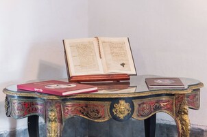 Uma mesa elaborada com um livro aberto e dois livros em cima.