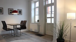 Uma área de jantar moderna com uma mesa, cadeiras, um vaso de planta e um abajur.