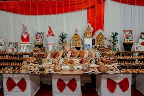Uma mesa com diversos produtos de panificação e decorações festivas.