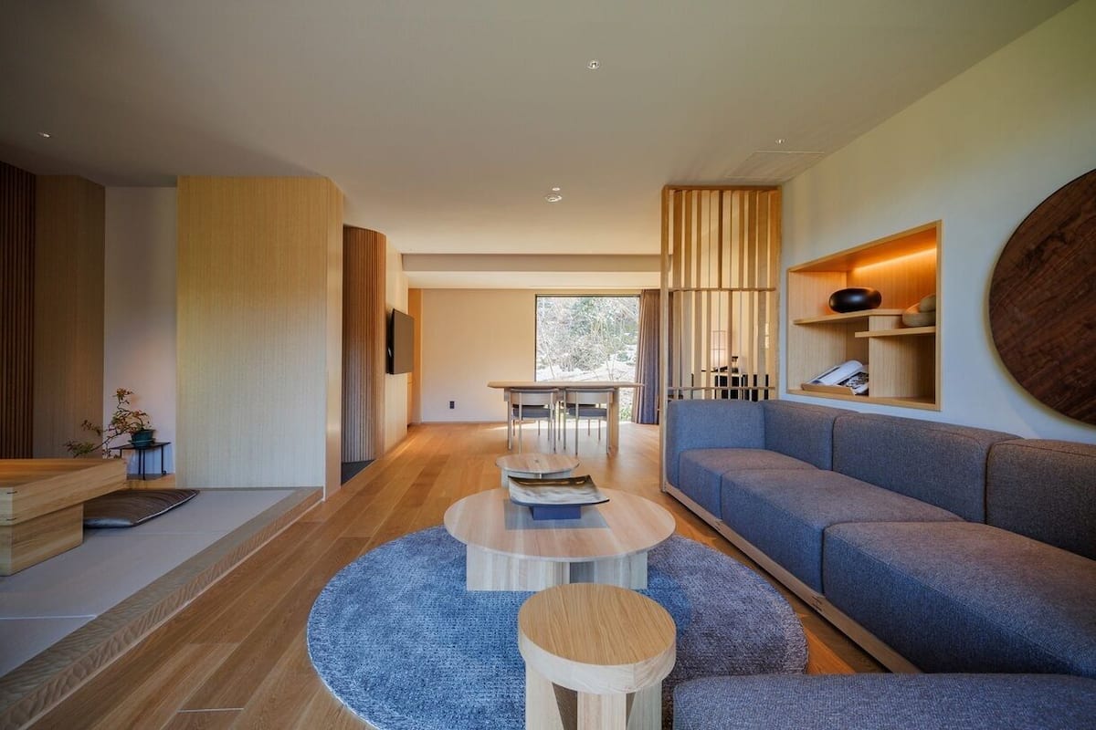 Uma sala de estar moderna com um sofá, mesa de centro e área de jantar com mesa e cadeiras.