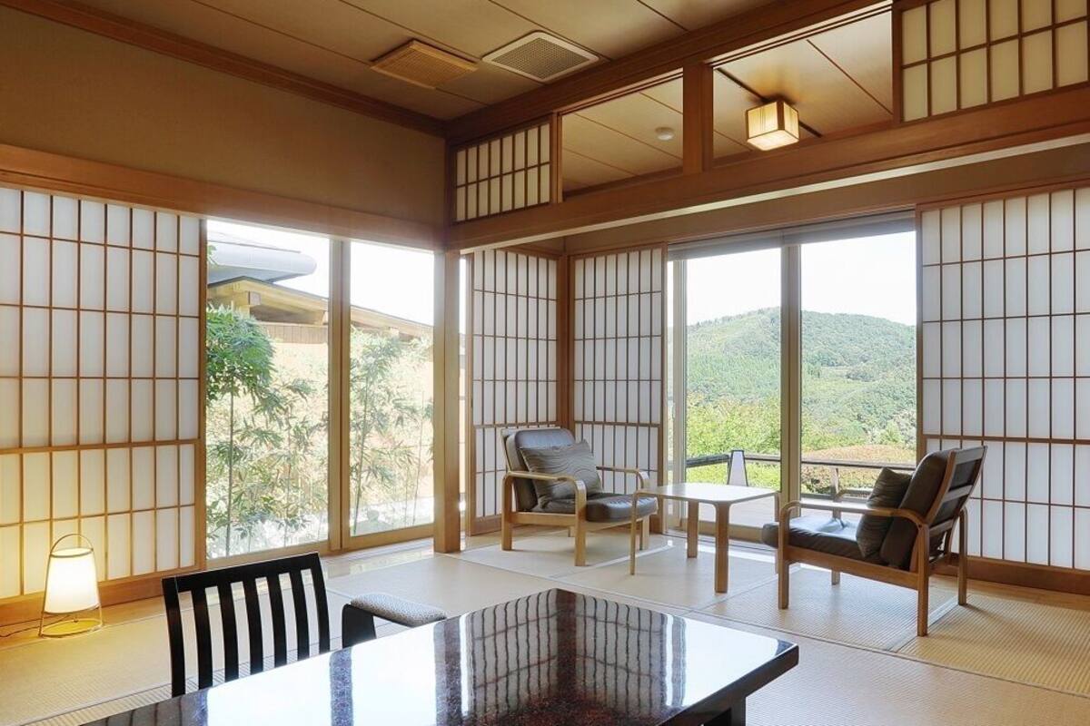 Um quarto em estilo japonês tradicional, com tatames, uma mesa baixa e portas deslizantes.