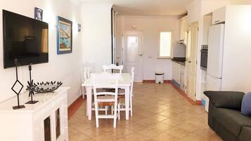 Apartamento Deluxe, 1 quarto, vista para o mar | Sala de estar | TV de ecrã plano
