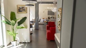 Um interior moderno com um sofá vermelho, uma planta em vaso e um candelabro.