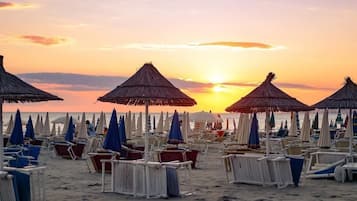 Uma praia privada, espreguiçadeiras, guarda-sóis de praia