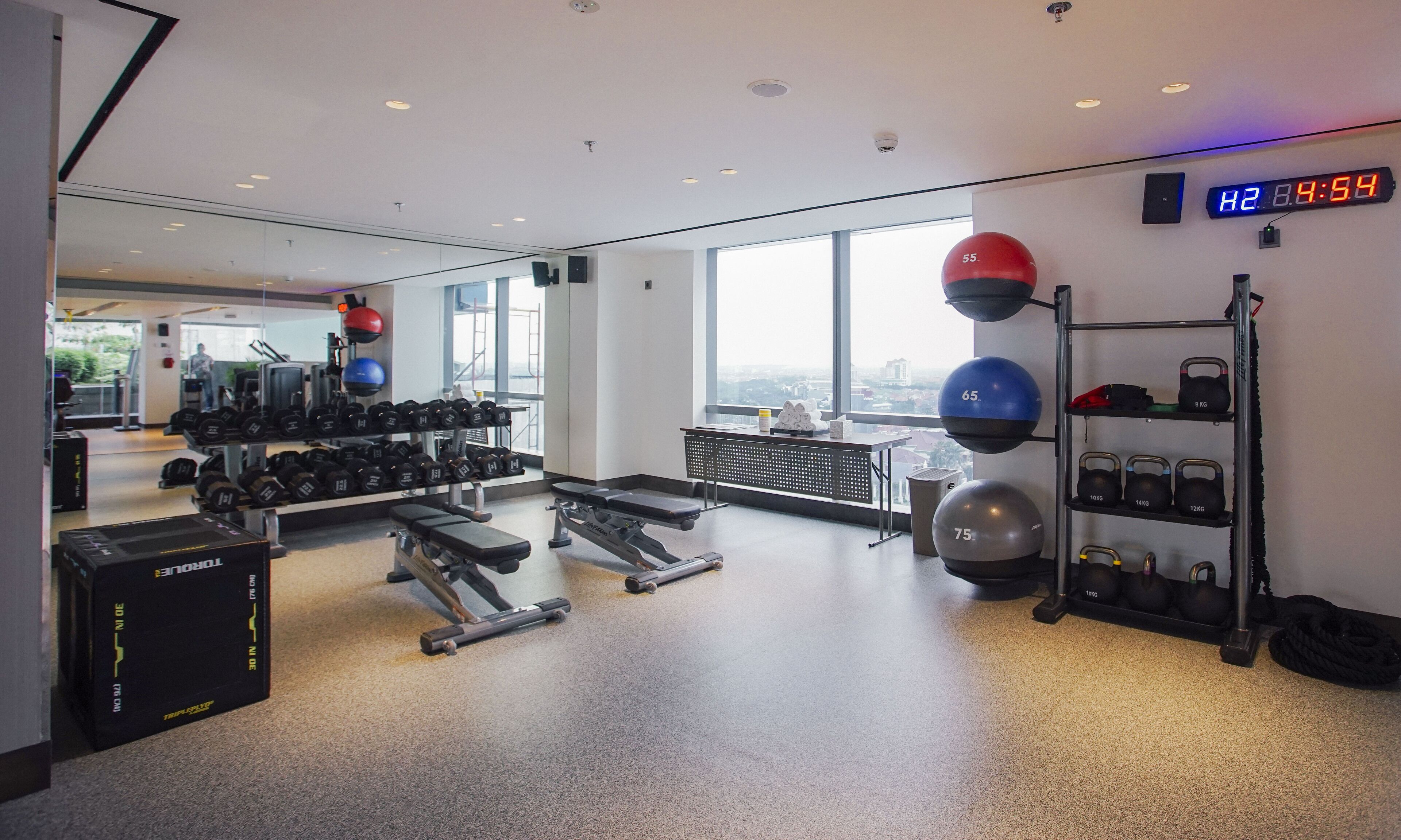 Uma academia moderna com diversos equipamentos de exercício, incluindo halteres, kettlebells e bolas de ginástica.