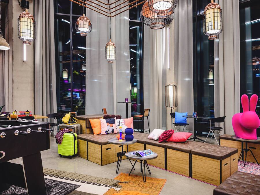 Uma área de estar moderna, com assentos, mesa de pebolim e luminárias de design exclusivo.