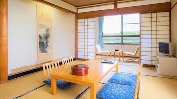 Um quarto japonês tradicional com tatames, uma mesa de madeira baixa e um sofá de tatame.
