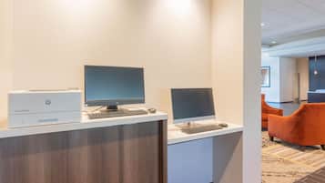 Balcão de recepção com duas impressoras HP, um monitor Dell e um teclado.