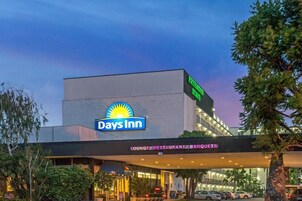 Edifício Days Inn com placa indicando que oferece lounge, restaurante e espaço para banquetes.