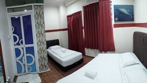 Quarto de hotel com duas camas, um guarda-roupa, casa de banho e um quadro na parede.