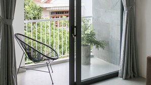 Quarto moderno com porta de vidro deslizante para uma varanda.