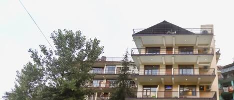 Um edifício residencial com vários andares, varandas, janelas grandes e telhado plano.