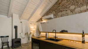 Uma cozinha moderna com fogão a lenha, pia e uma garrafa de vinho.