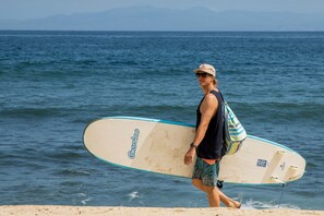 Uma pessoa carregando uma prancha de surf com a marca 