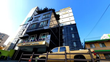 Um hotel com design arquitetônico moderno, com vários andares e uma entrada imponente.