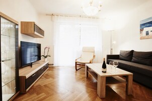 Apartamento superior (First Class) | Sala de estar | TV