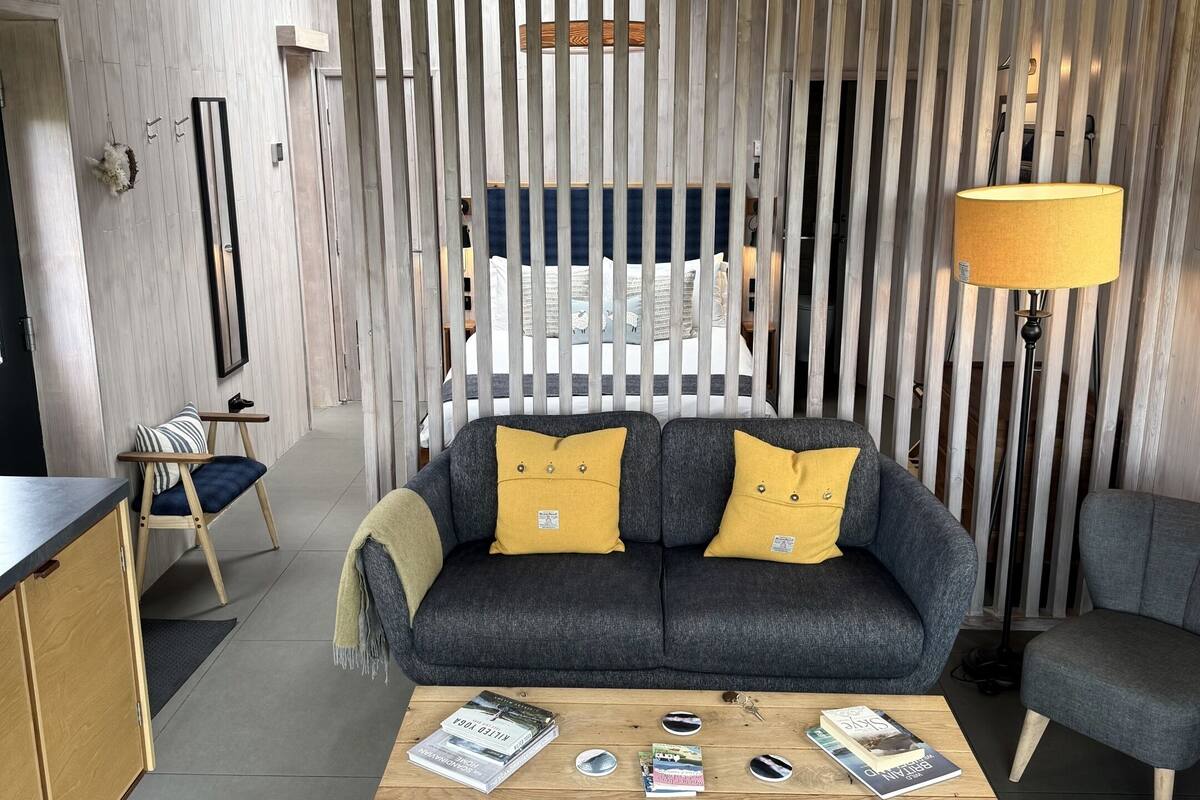 Uma sala de estar moderna com sofá, mesa de centro e abajur.
