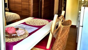 Uma cozinha compacta com mesa, cadeiras e geladeira.